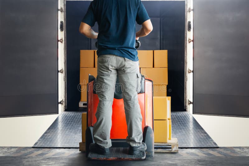 Workers Unloading Package Boxes into Container. Trucks Loading Dock ...