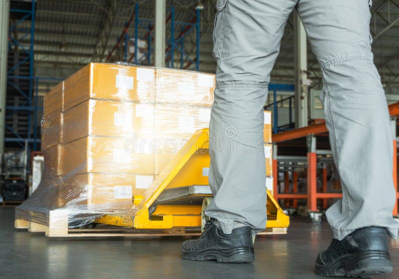 Workers Using Hand Pallet Jack Unloading Package Boxes. Commerce Supply ...