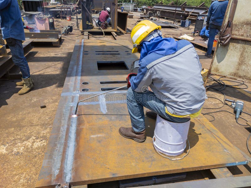 Workers are Using Heating Torch To Burning Bending Steel Plates that is ...