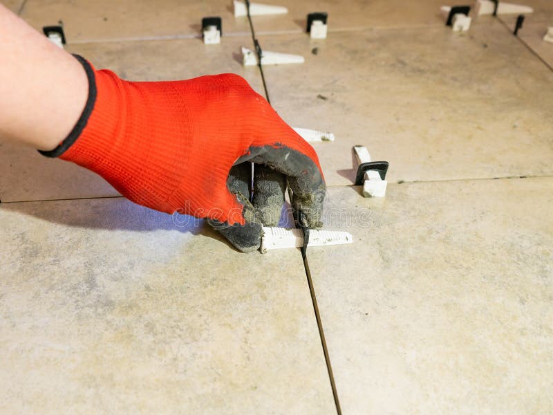 Workers are Using Plastic Clamps and Wedges To Leveling the Ceramic ...