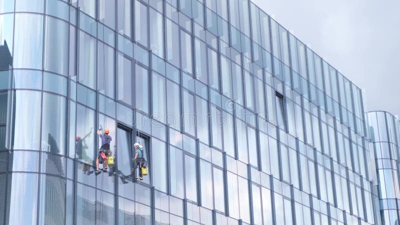 Workers Wash Windows on a Glass Skyscraper. Work As a Window Washer ...