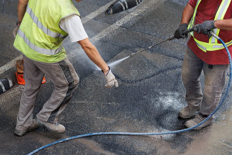 Workers Wearing Reflective Vests Doing Maintenance Work on the Asphalt ...