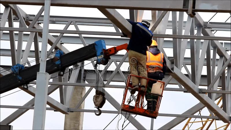 Workers Weld Metalwork at a Height with the Help of an Industrial Hoist ...