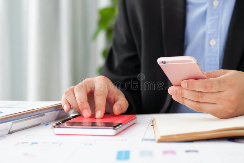 Workers Who Use Mobile Phones while Using Calculators Stock Photo ...