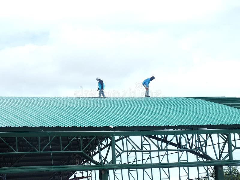Workers Work on Building Roofs in High Places. on the Background of the ...