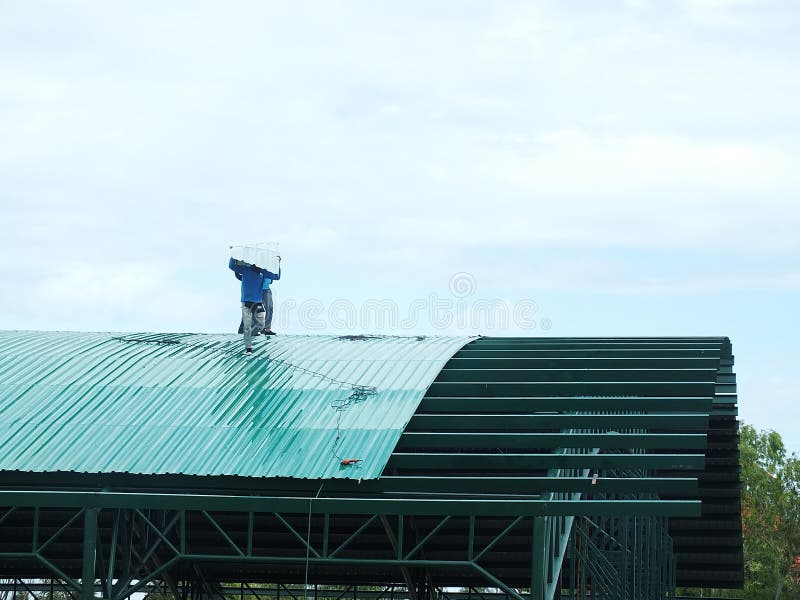 Workers Work on Building Roofs in High Places. on the Background of the ...