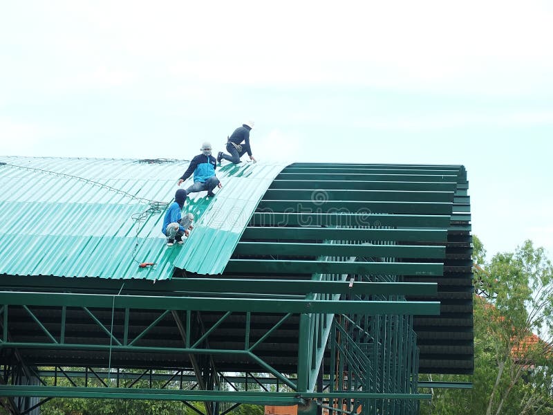 Workers Work on Building Roofs in High Places. on the Background of the ...