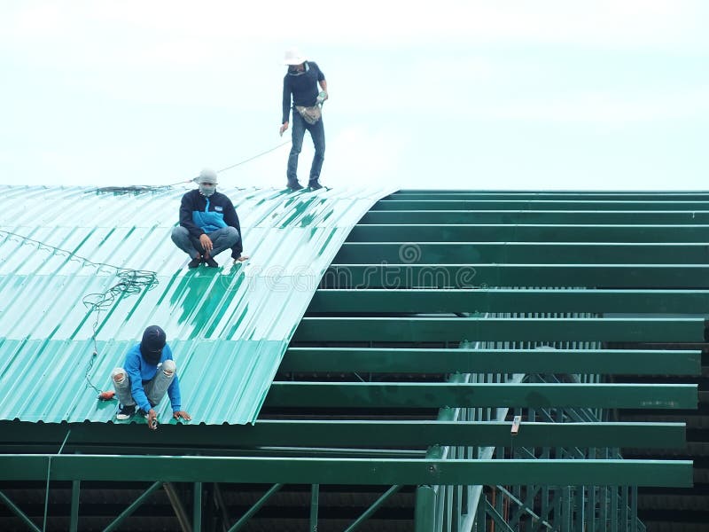 Workers Work on Building Roofs in High Places. on the Background of the ...