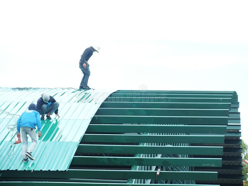 Workers Work on Building Roofs in High Places. on the Background of the ...