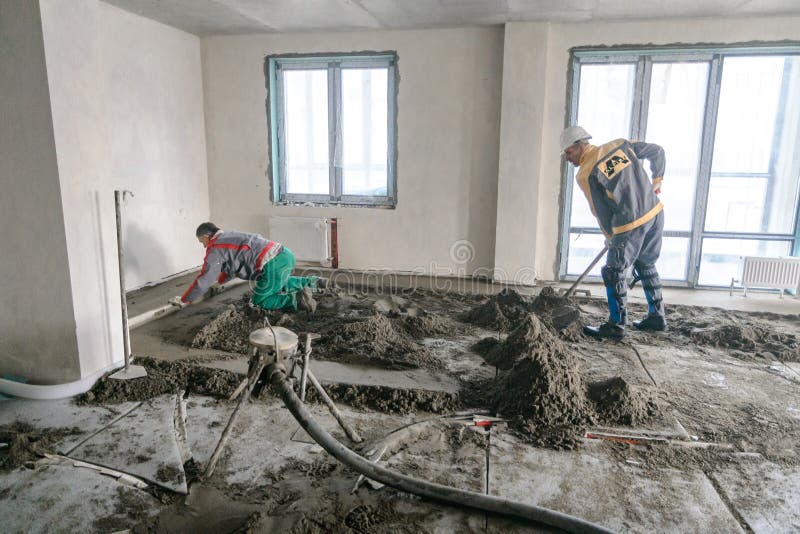 Workers in Work Clothes are Doing Their Job, Leveling the Floor and ...