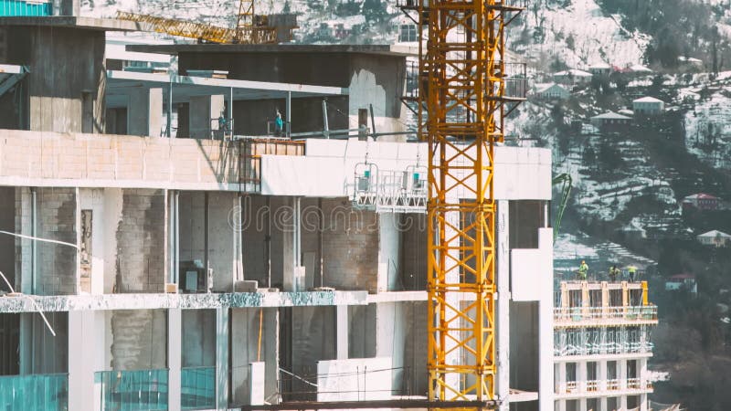 Workers Work in a Construction Cradle, on Scaffolding during the ...