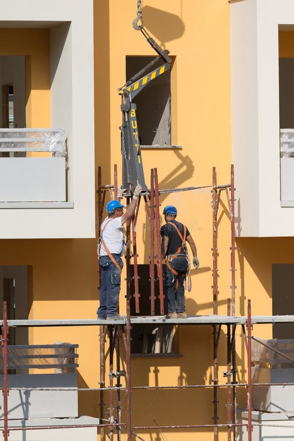 Workers at Work on a Scaffold in a Building Site for the Construction ...