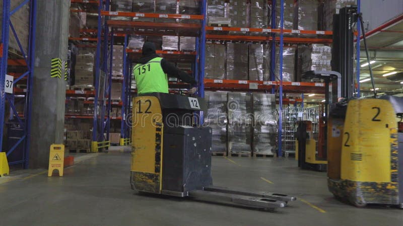Workflow in a Modern Warehouse. Worker on a Modern Forklift. Working in ...