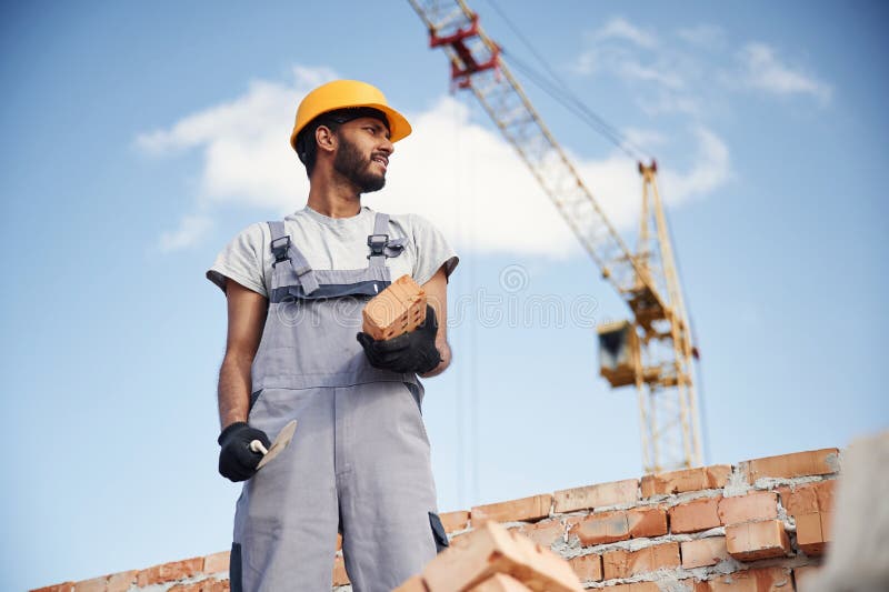 Showing and Holding Little Shovel and Brick. Handsome Indian Man is on ...