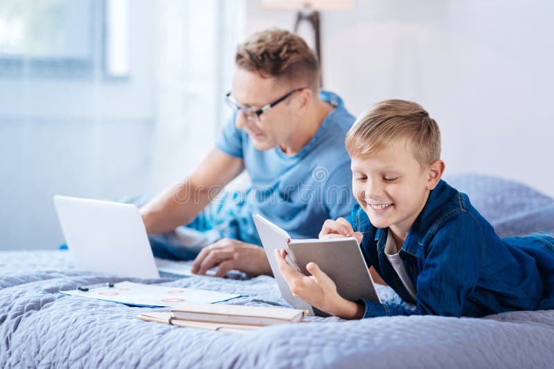 Pre-teen Boy Doing Math Homework while His Father Working Stock Image ...