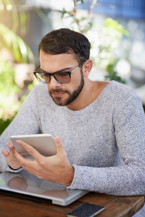 Working Away at His Local Cafe. a Handsome Young Man Using a Digital ...
