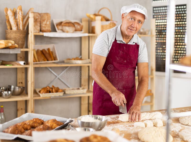 Senior Man Works in Bakery As Baker, Cuts Dough into Portions, Forms ...