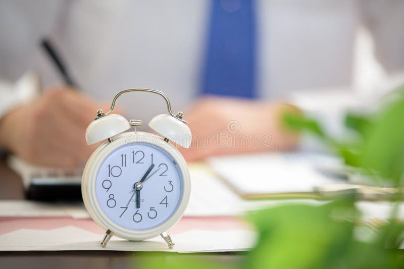Working Businessman and White Alarm Clock. Work Time Concept Stock ...