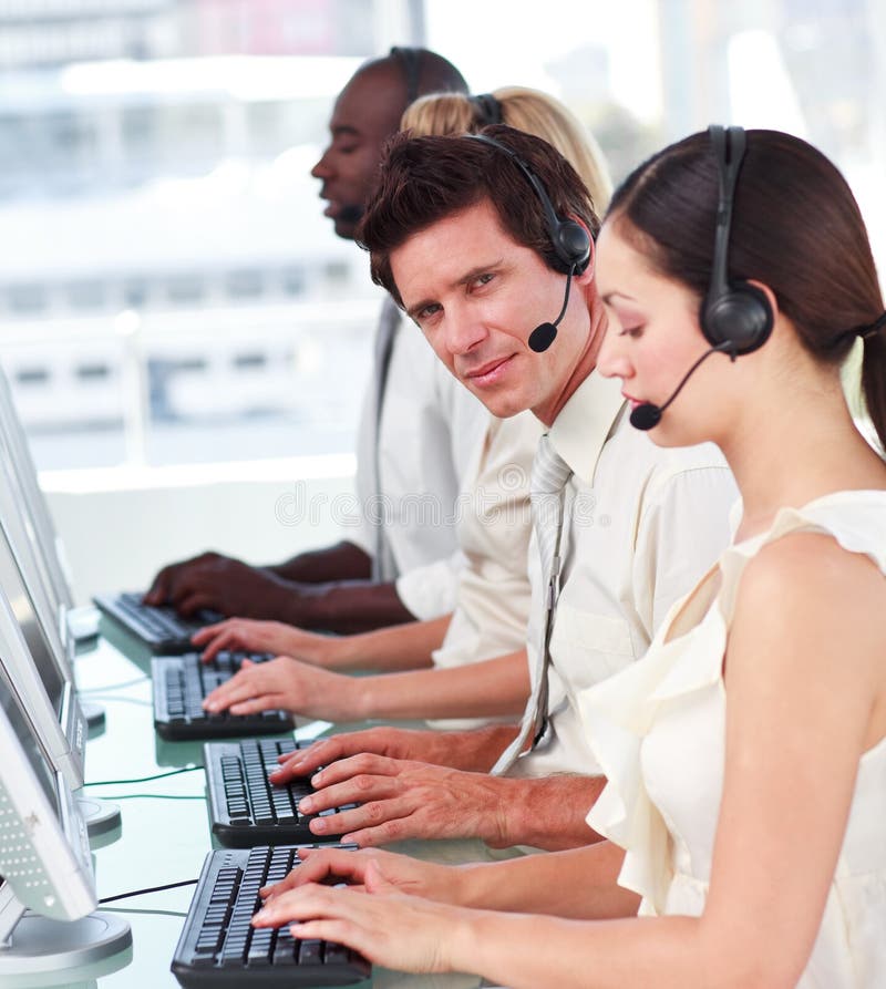 Call Centre Workers Sitting in Line while Helping People Stock Photo ...