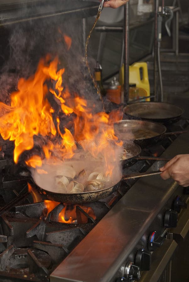 Professional Chef in a Commercial Kitchen Cooking Flambe Style Stock ...