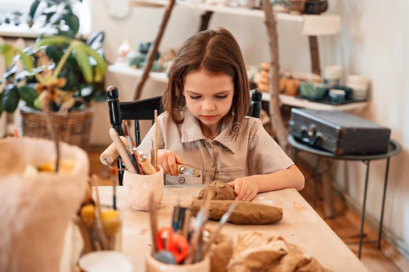Working with Clay. Little Girl is Learning How To Do Pottery in the ...