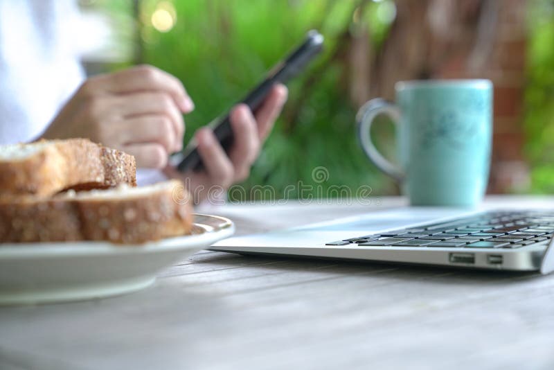 Working on the Computer and Cell Phone while Having Breakfast Stock ...