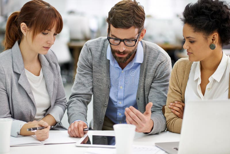 Working through Digital Paperwork. a Group of Young Office ...