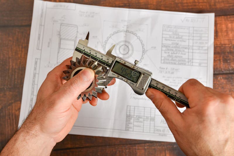 A Working Engineer Checks the Size of a Bevel Gear with an Electronic ...