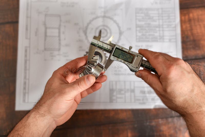 A Working Engineer Checks the Size of a Bevel Gear with an Electronic ...