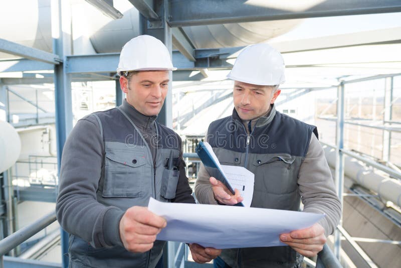 Working Engineers with Project or Drawing Plan Stock Photo - Image of ...