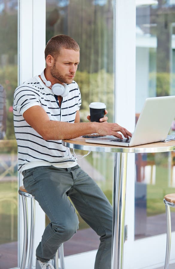 Working on the Go. a Handsome Young Man Working on a Laptop Outside ...