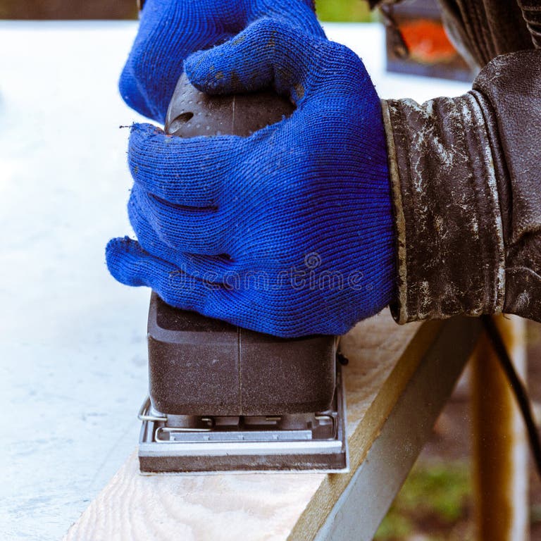 Men& X27;s Hands in Blue Gloves Work with Power Tools. Working with a ...