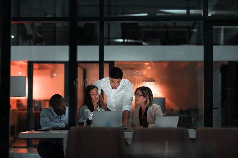 Working Hard while the Rest of the World Sleeps. Colleagues Using a ...