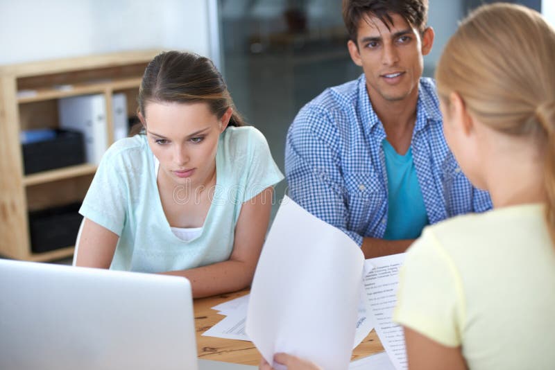 Working Their Latest Project. Three Colleagues Working in an Office ...
