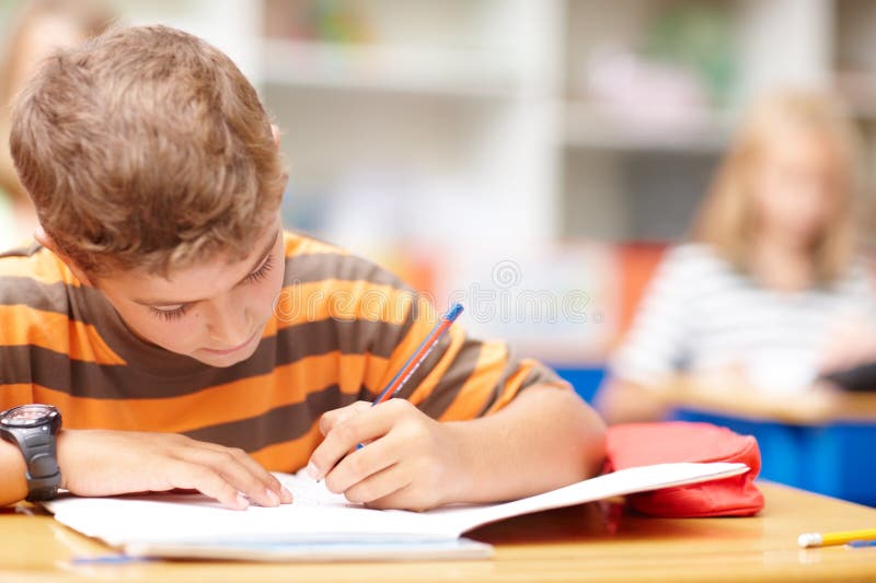 Working Hard for Top Results. School Boy Writing in His Notebook at His ...