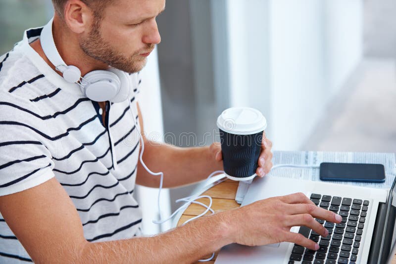 Working at His Own Pace. a Handsome Young Man Working on a Laptop ...