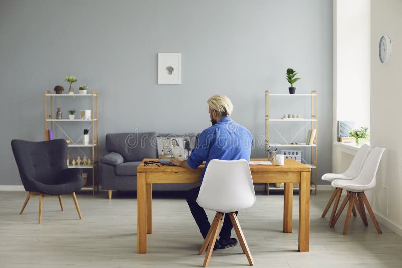 Working from Home. Back View of Young Guy Using Laptop Computer for ...