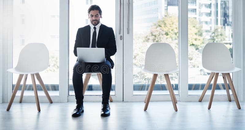 Working while I Wait. a Young Businessman Using a Laptop while Waiting ...