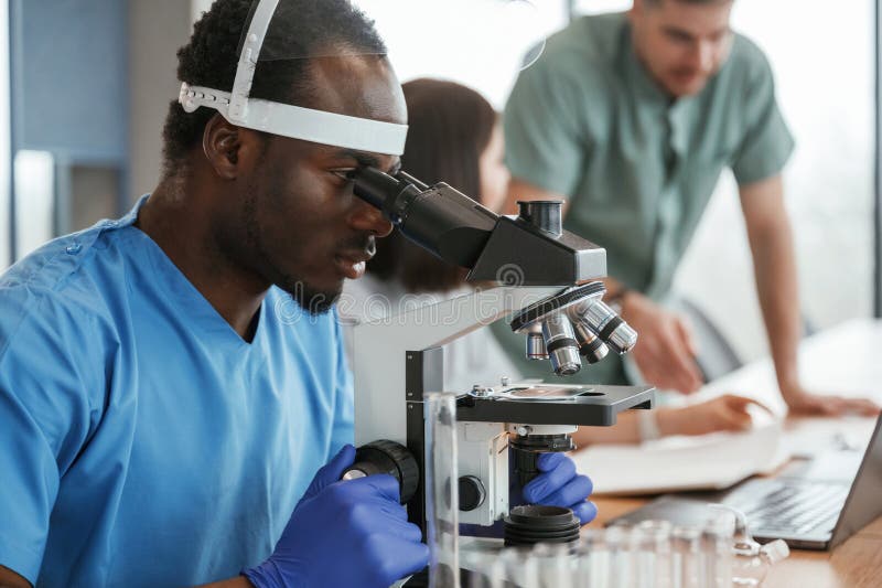 Working in a Lab with Test Tubes and Microscope. Group of Doctors are ...