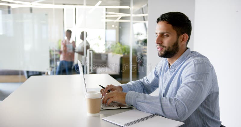 Working on Laptop, Man Taking Notes with Coffee Cup on Desk in Office ...