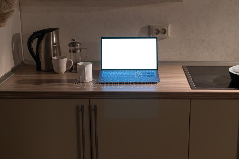 A Working Laptop with a White Screen Stands on the Kitchen Table Next ...