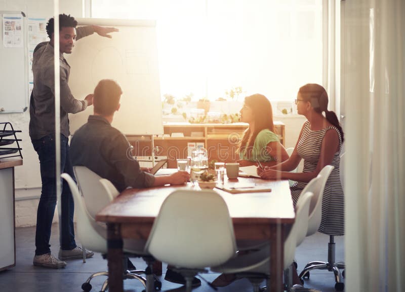 Working Late into the Day. a Group of Coworkers in a Boardroom Meeting ...