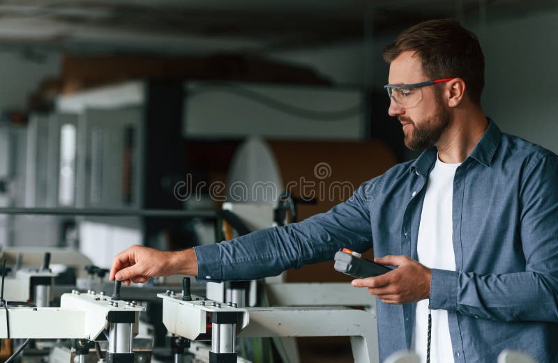 Working with Machine. Handsome Man is at the Factory of Creating Eco ...