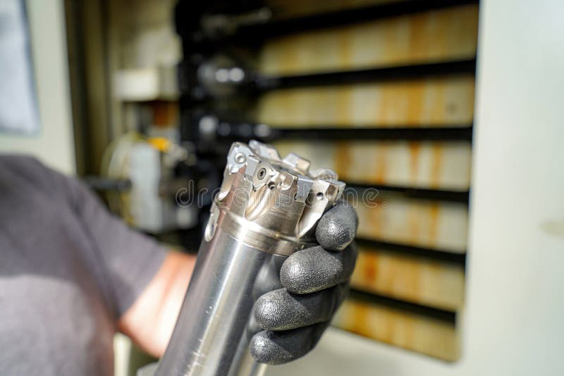 A Working Machine Operator Inspects and Changes a Cutting Tool in the ...