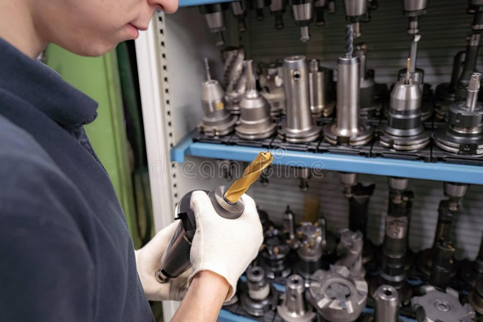 A Working Machine Operator Inspects a Cutter for a CNC Machine from a ...
