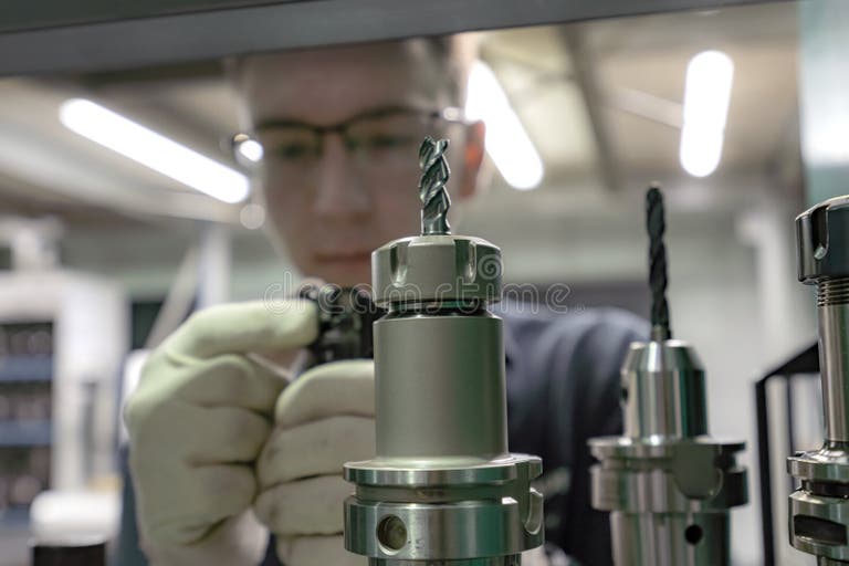 A Working Machine Operator Inspects a Cutter for a CNC Machine from a ...