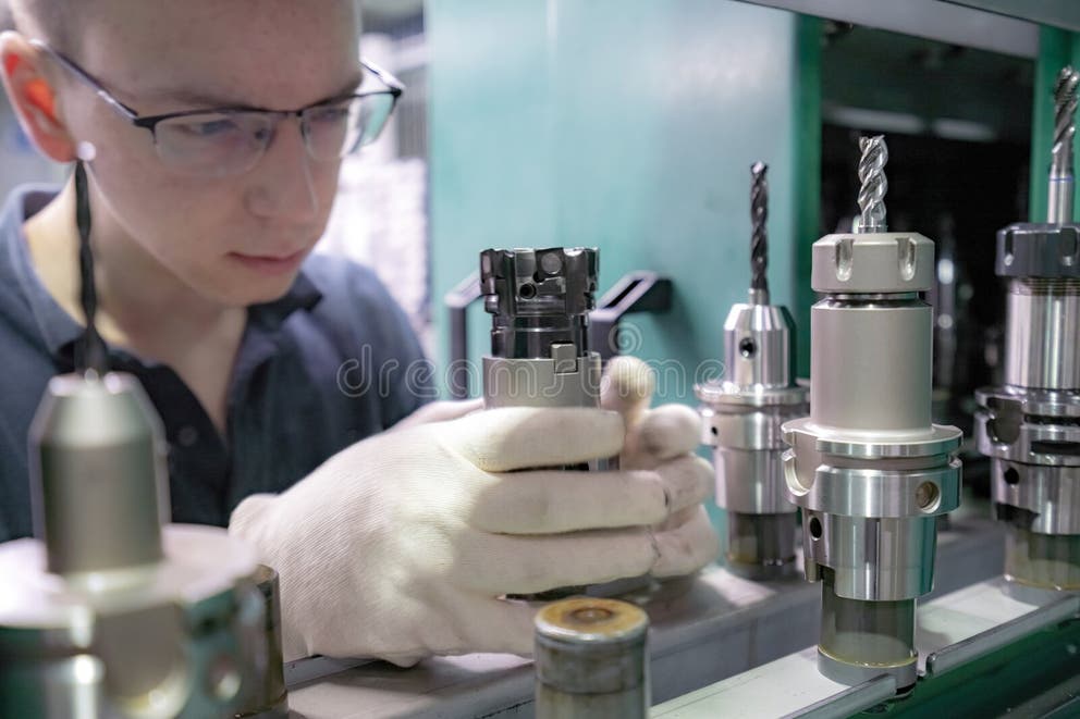 A Working Machine Operator Inspects a Cutter for a CNC Machine from a ...