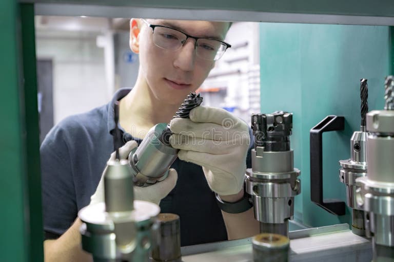 A Working Machine Operator Inspects a Cutter for a CNC Machine from a ...