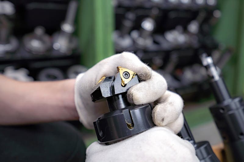 A Working Machine Operator Inspects A Cutter For A Cnc Machine From A