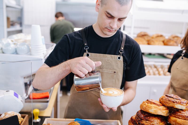 Working Male Baker Putting Cream in Coffee Cup from a Metal Jug Stock ...